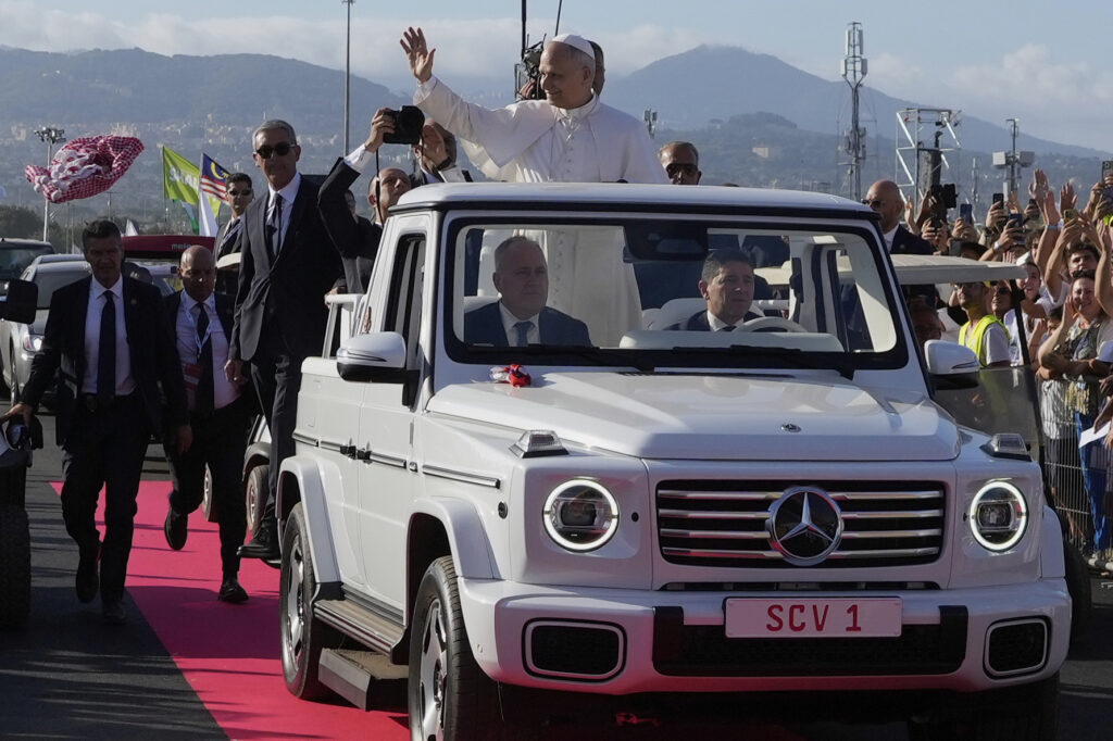 A faithful throws a keffiyeh as Pope Leo XIV arrives for a Mass with young people participating in the Youths Jubilee at the Tor Vergata field in Rome, Sunday, Aug. 3, 2025.